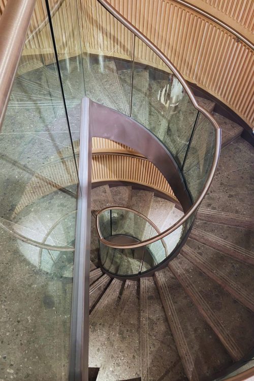 Commercial Helical staircase with stone treads and frameless glass ...